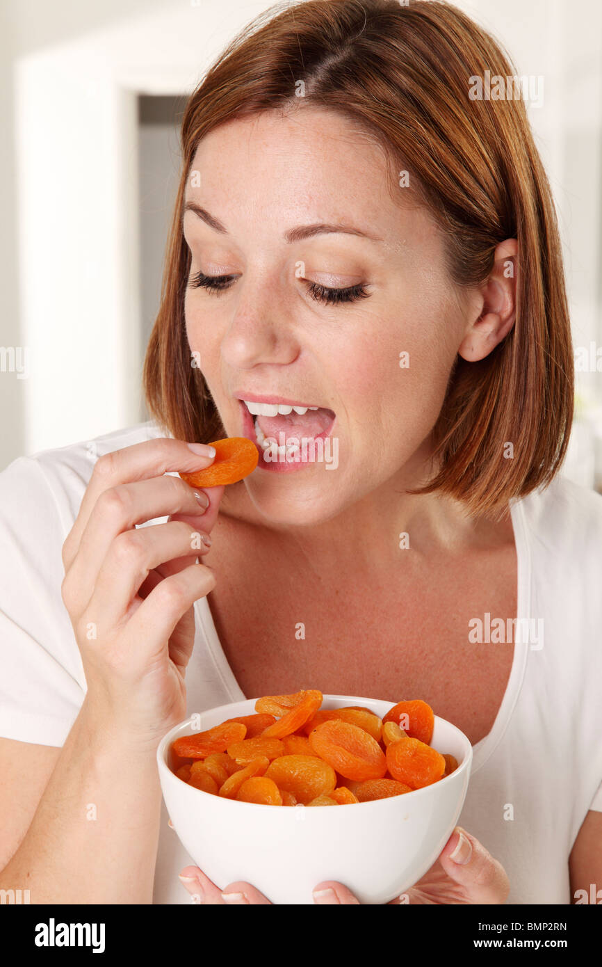 WOMAN EATING DRIED APRICOTS Stock Photo - Alamy