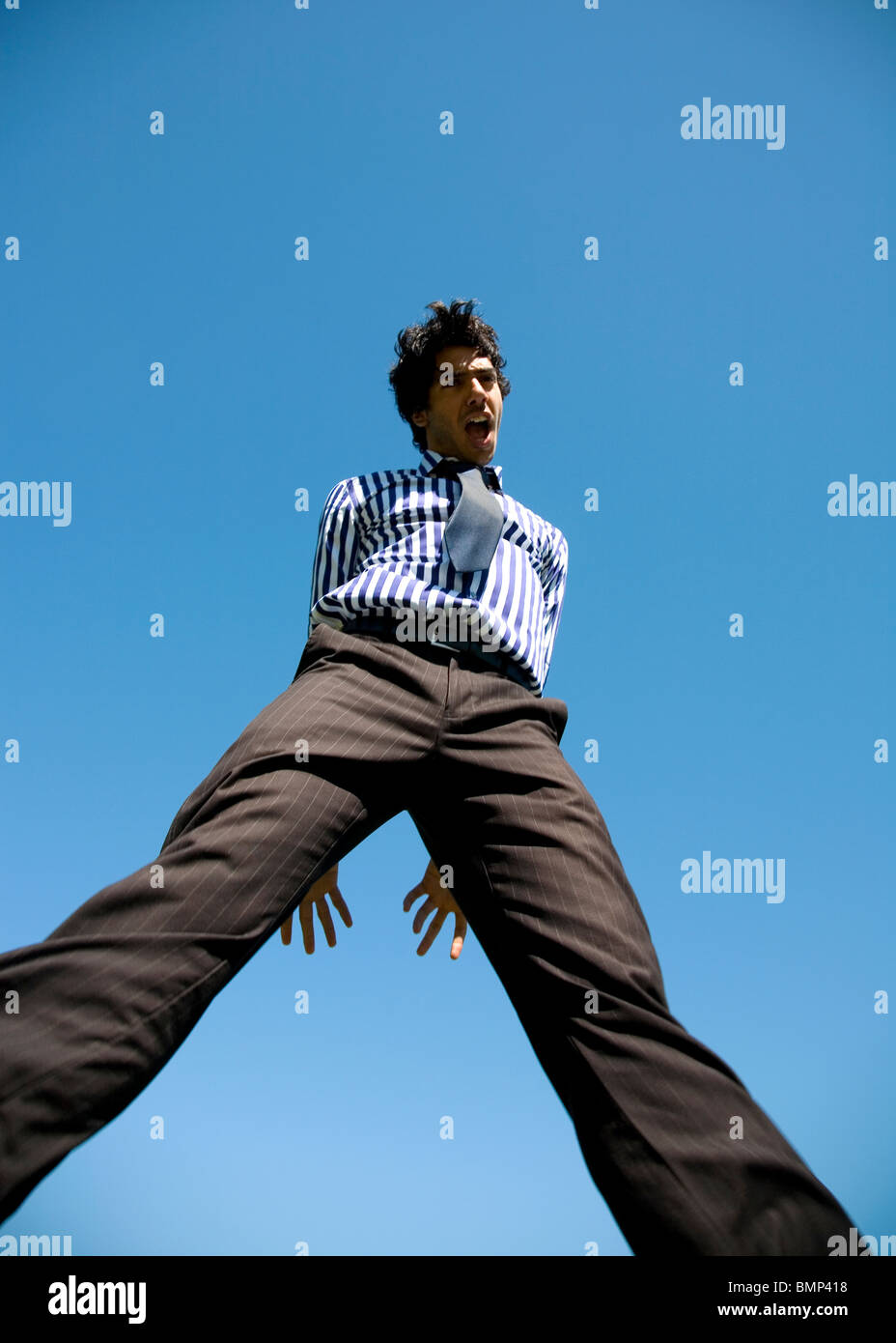 Young man in business/ formal dress jumping against blue sky Stock ...