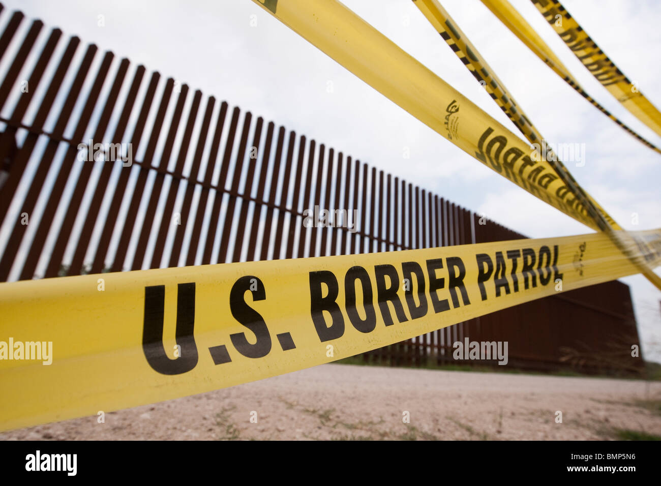 Yellow U.S. Border Patrol barricade tape near the border wall between ...