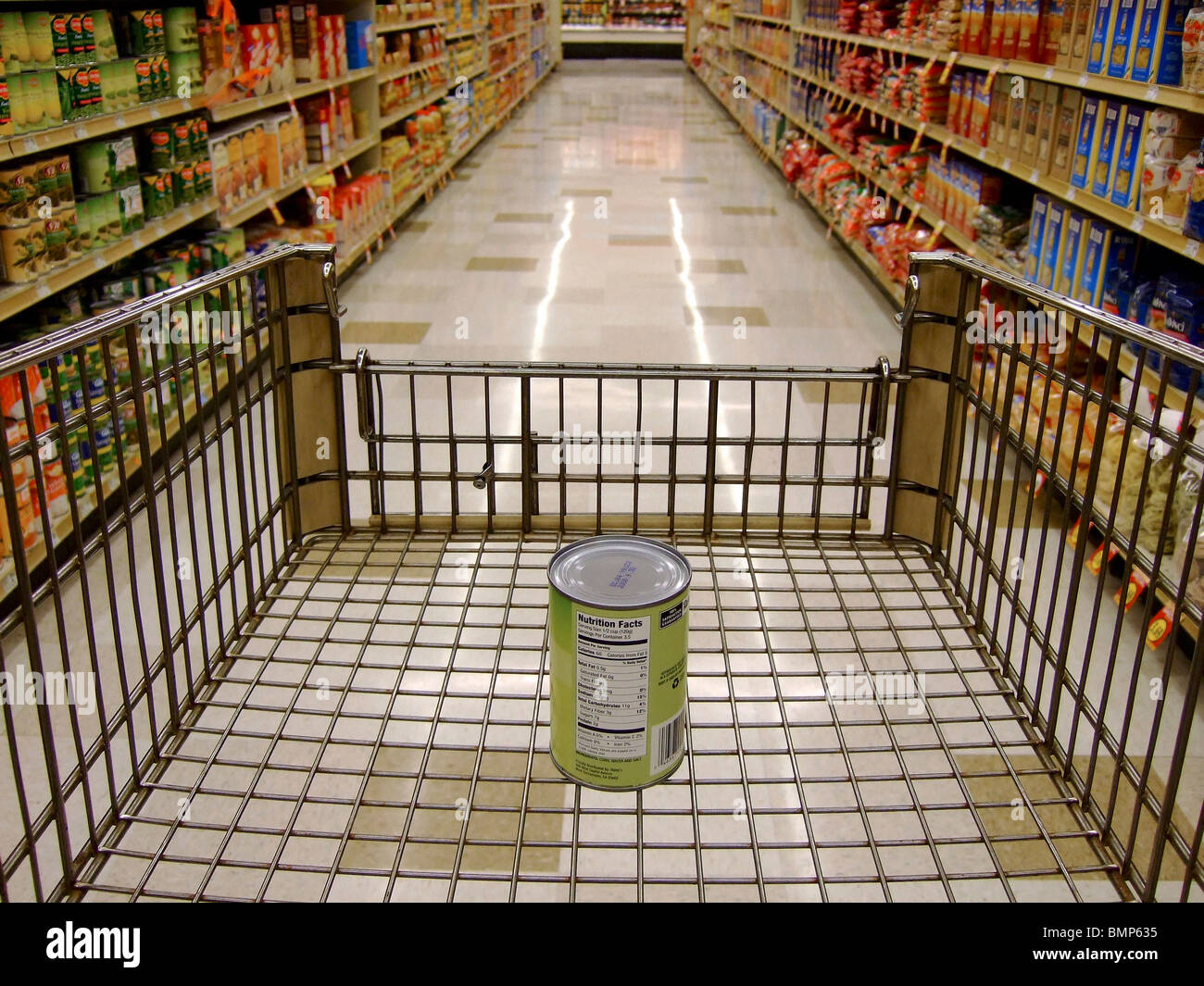 Close up of a grocery shopping cart with one can of goods in the cart ...