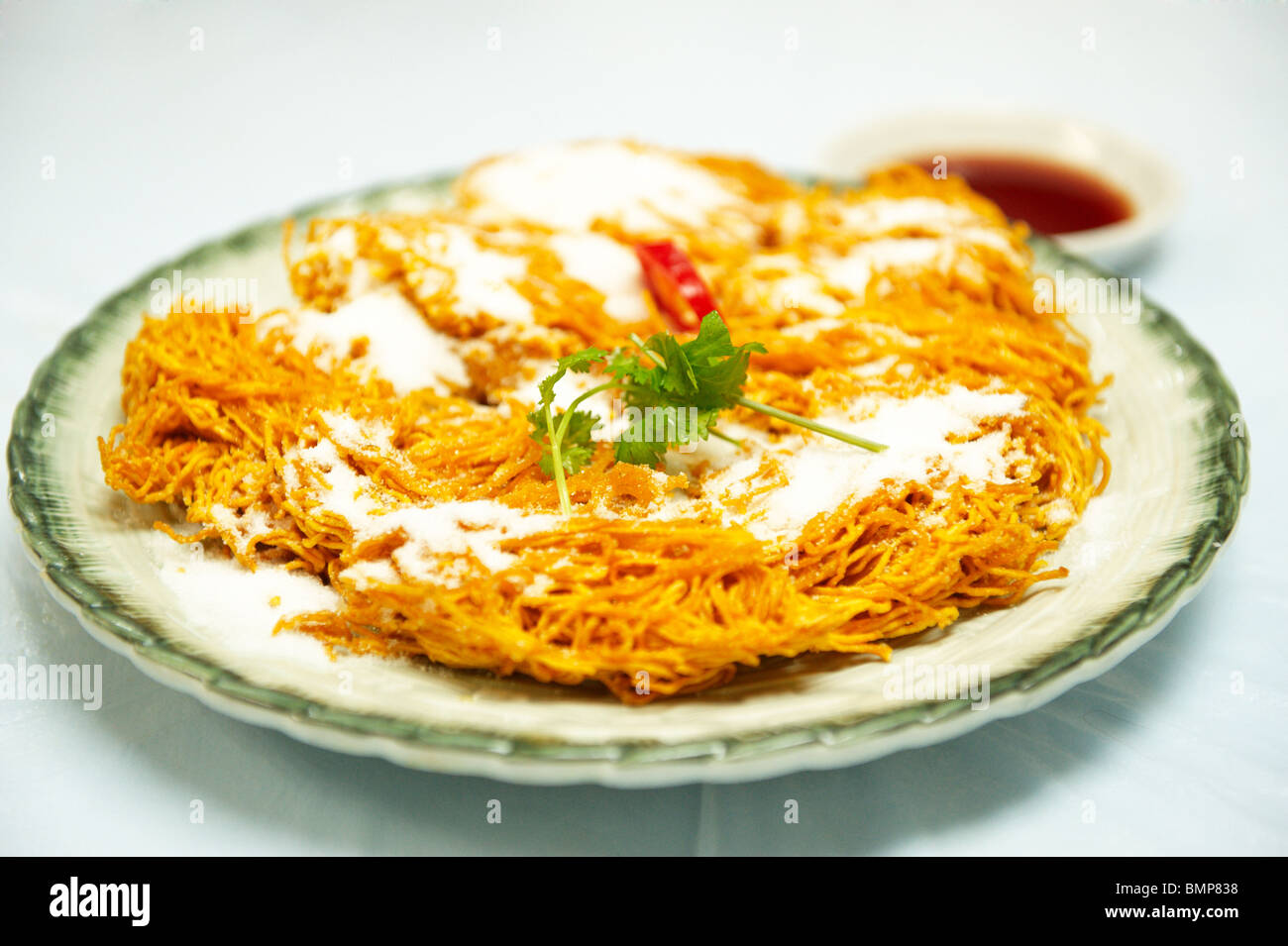 Cold and dry noodle dish with sugar powder on a china plate with ...