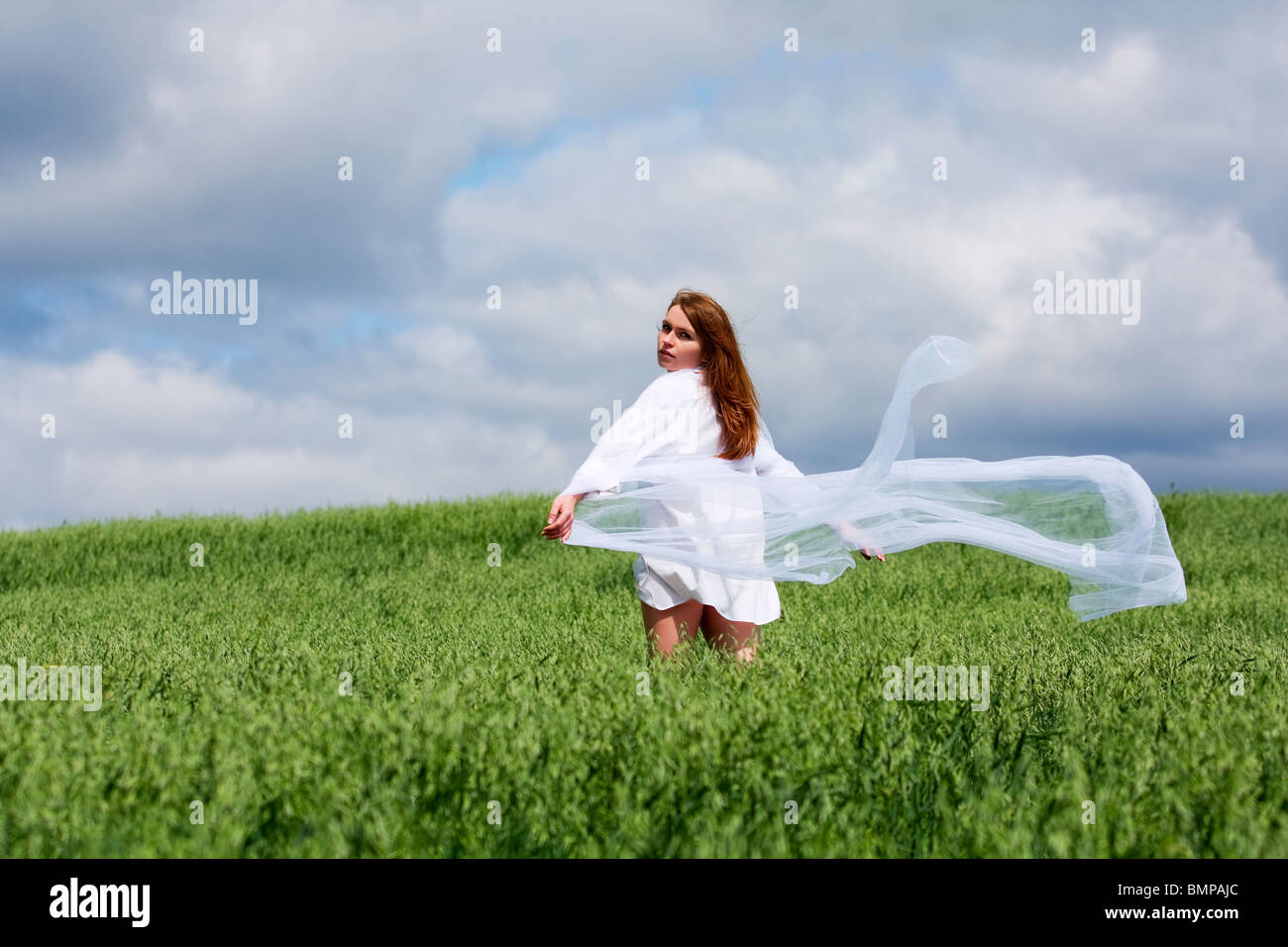 Happy young woman walking in a field Stock Photo - Alamy