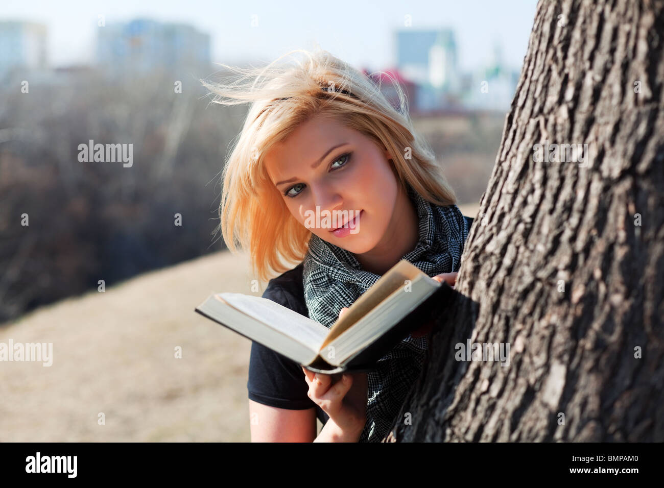 Thoughtful young woman reading a book on nature Stock Photo - Alamy