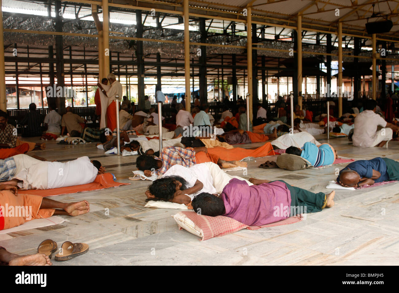 Pilgrims sleeping at a shed, at the Guruvayoor temple, Kerala, India ...
