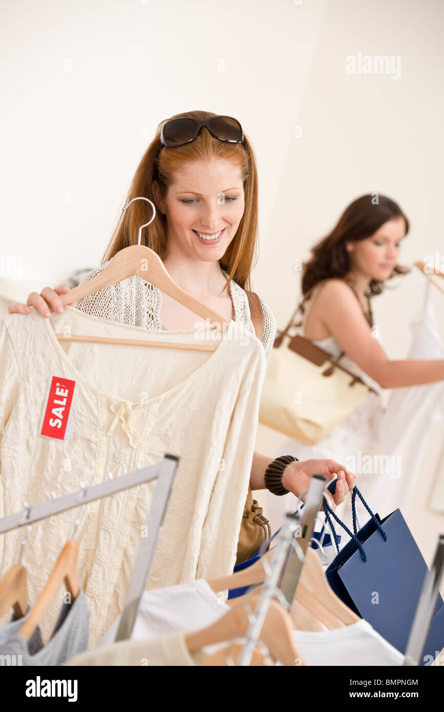 Fashion shopping - Two happy young woman choose clothes in shop Stock ...