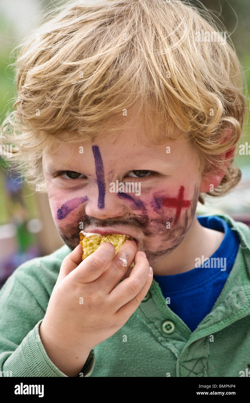 Young two year old toddler with his face painted as a pirate eating ...