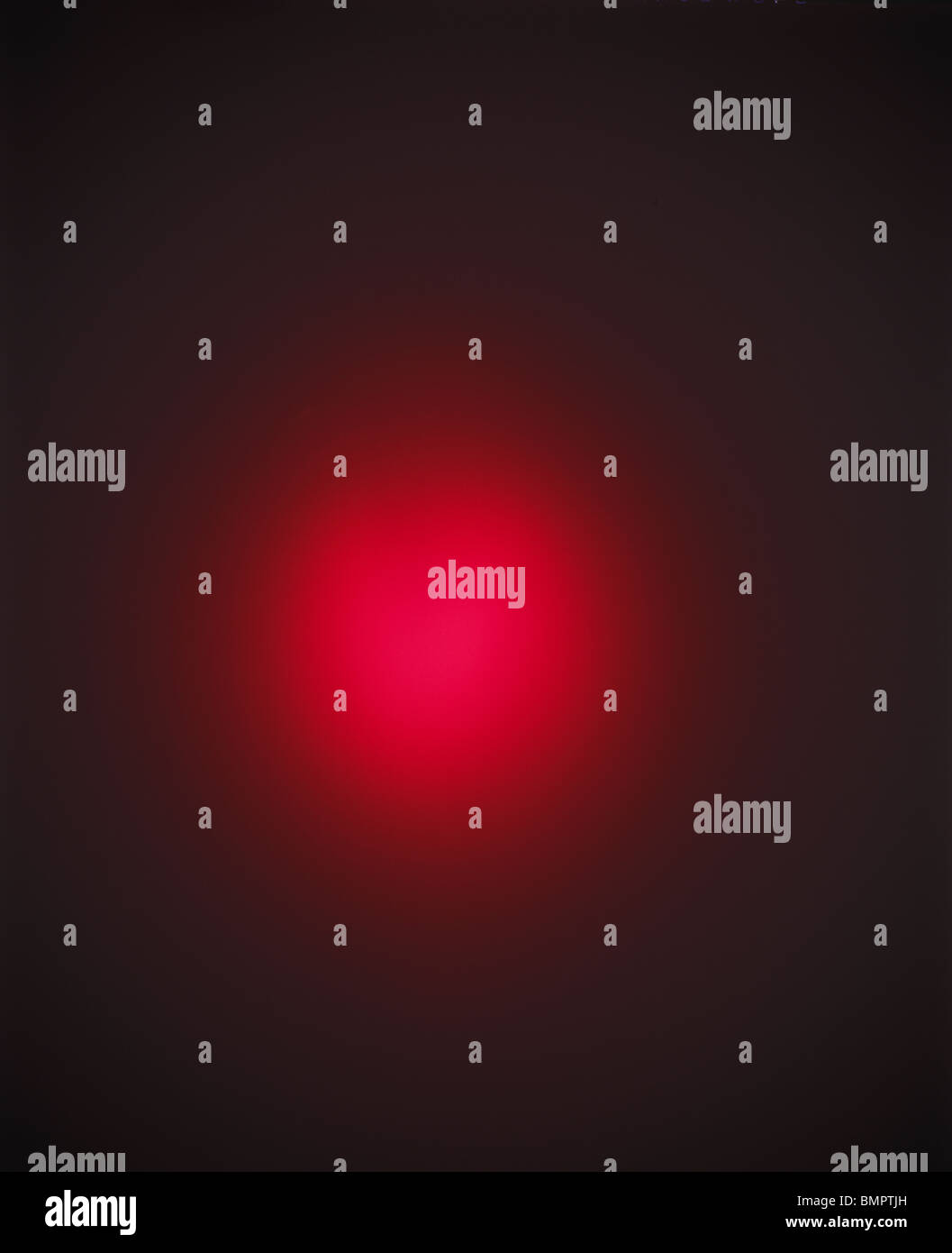 Central red light glow against dark background Stock Photo - Alamy