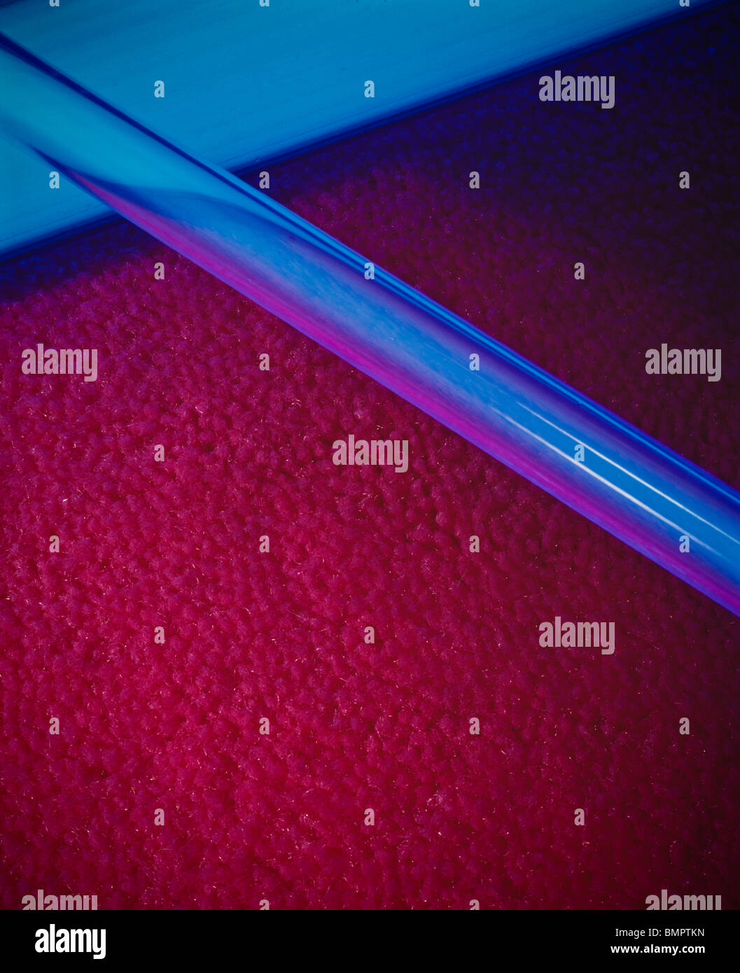 Blue light tube diagonal across red carpet Stock Photo - Alamy