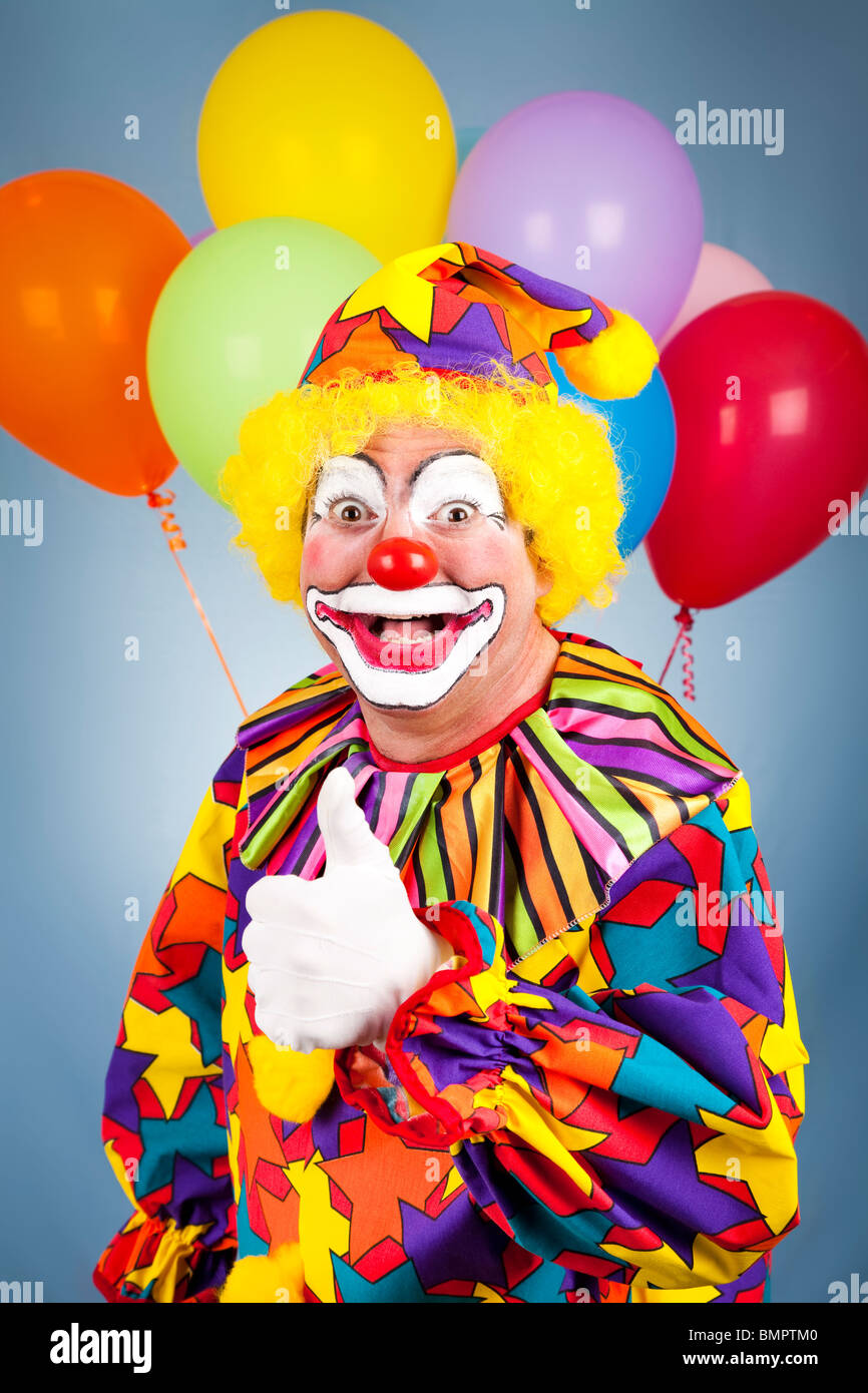 Happy clown with balloons giving thumbs up sign Stock Photo - Alamy