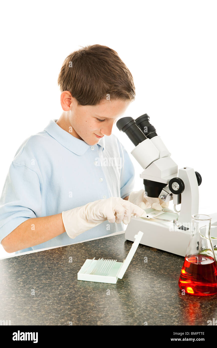 Young school boy in science class, looking through the microscope ...