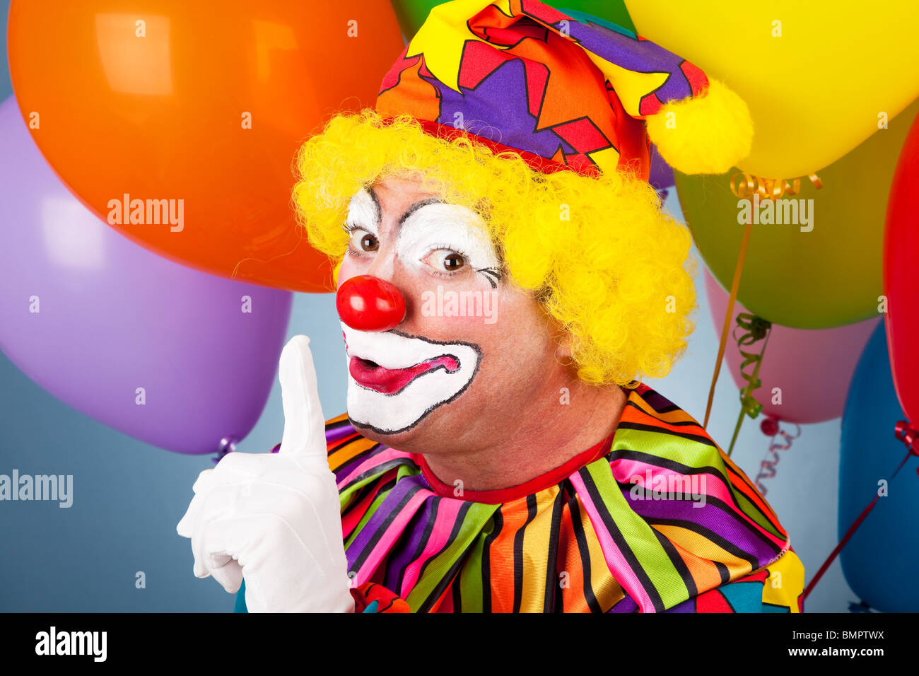 A colorful clown putting his finger to his lips so you will be quiet ...