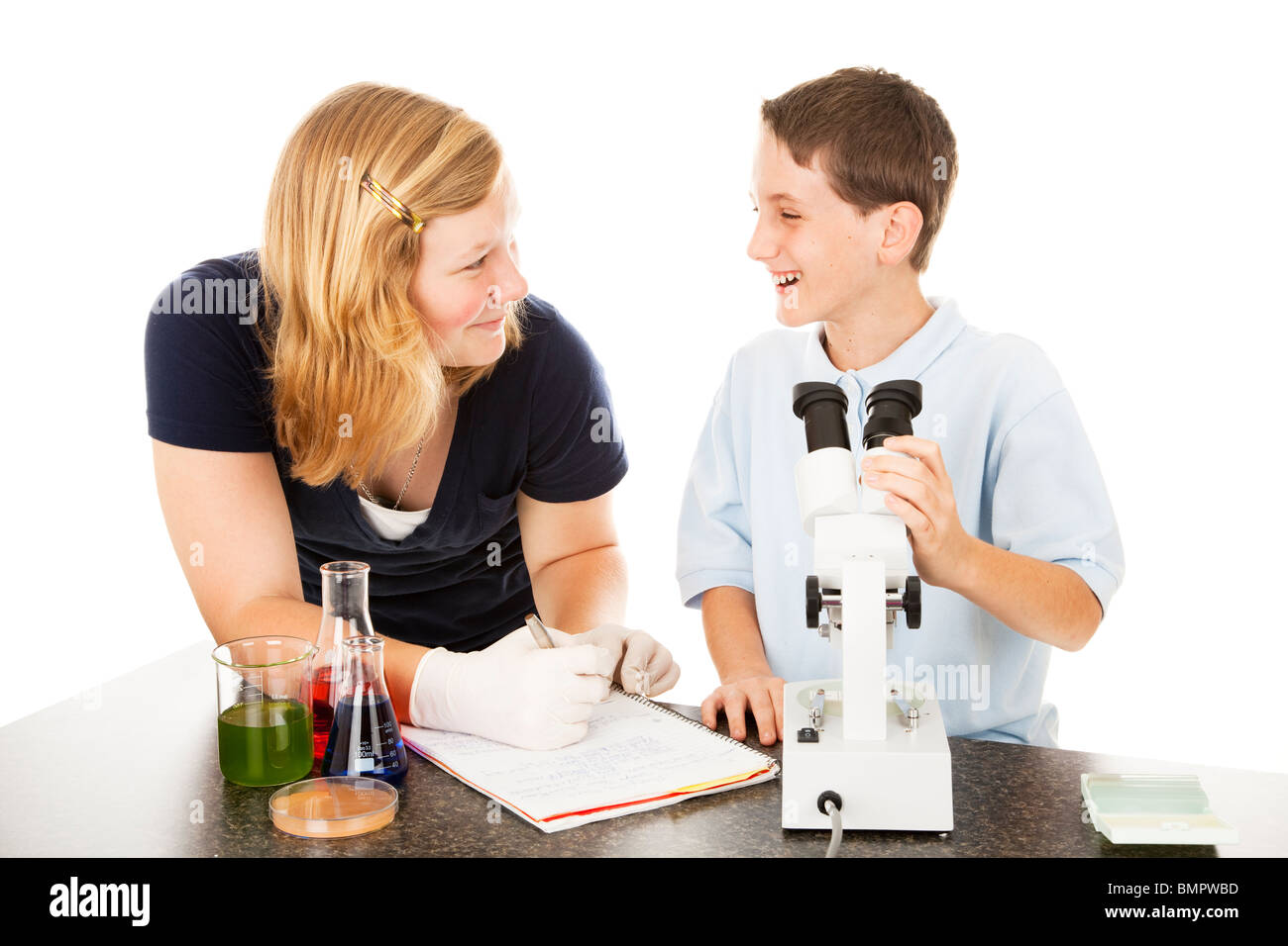 Kids in science class looking through microscope and taking notes Stock ...