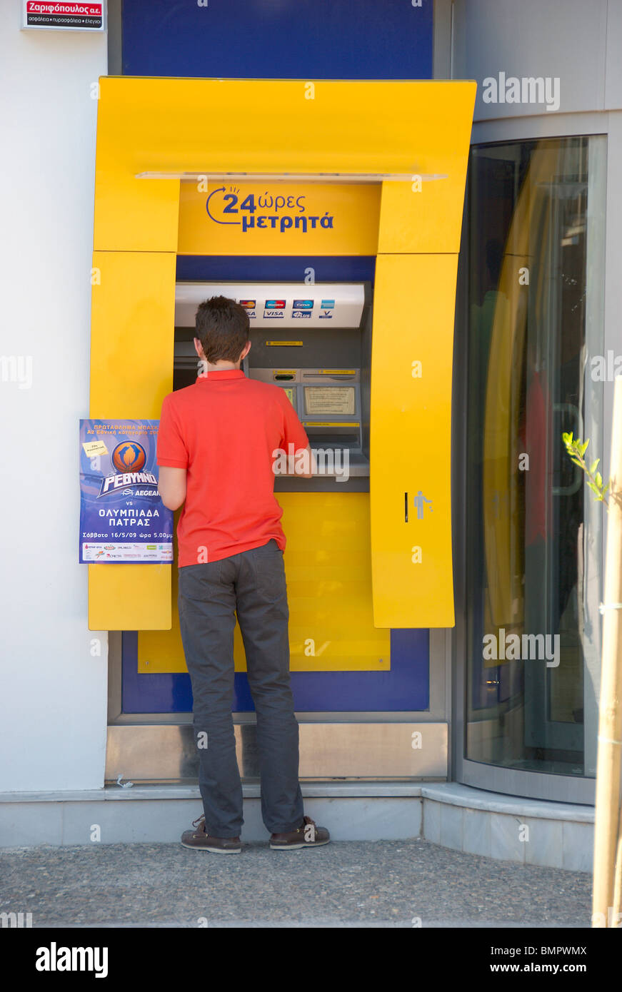Young man at Greek cash machine Stock Photo - Alamy