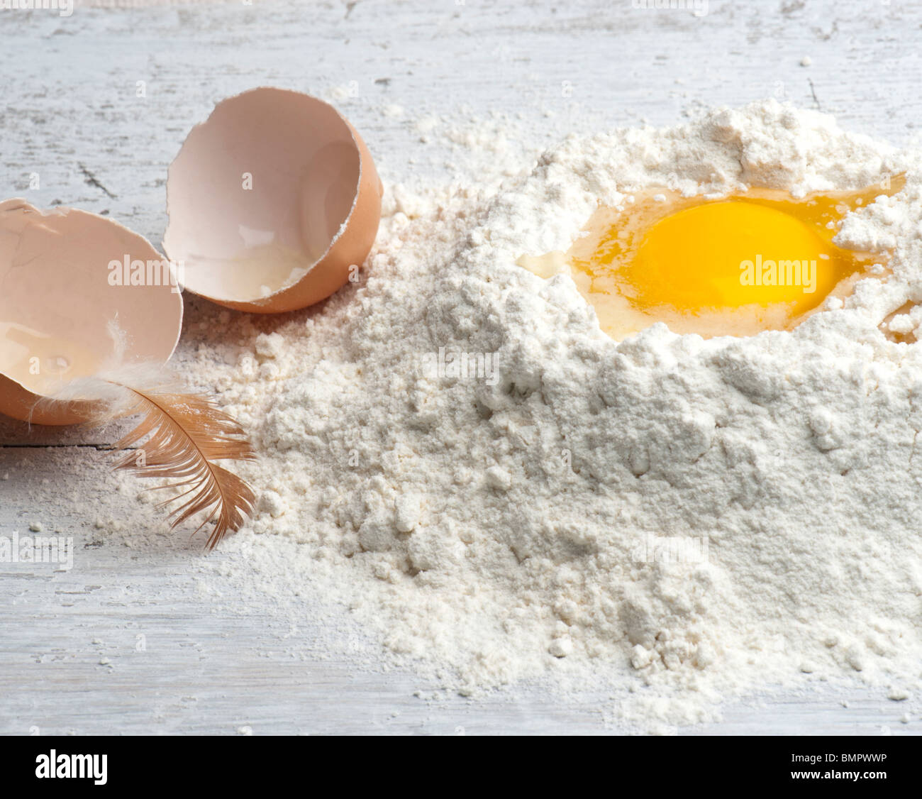 A Cracked Egg In Flour, With Shell and Hen Feather To The Side Stock ...