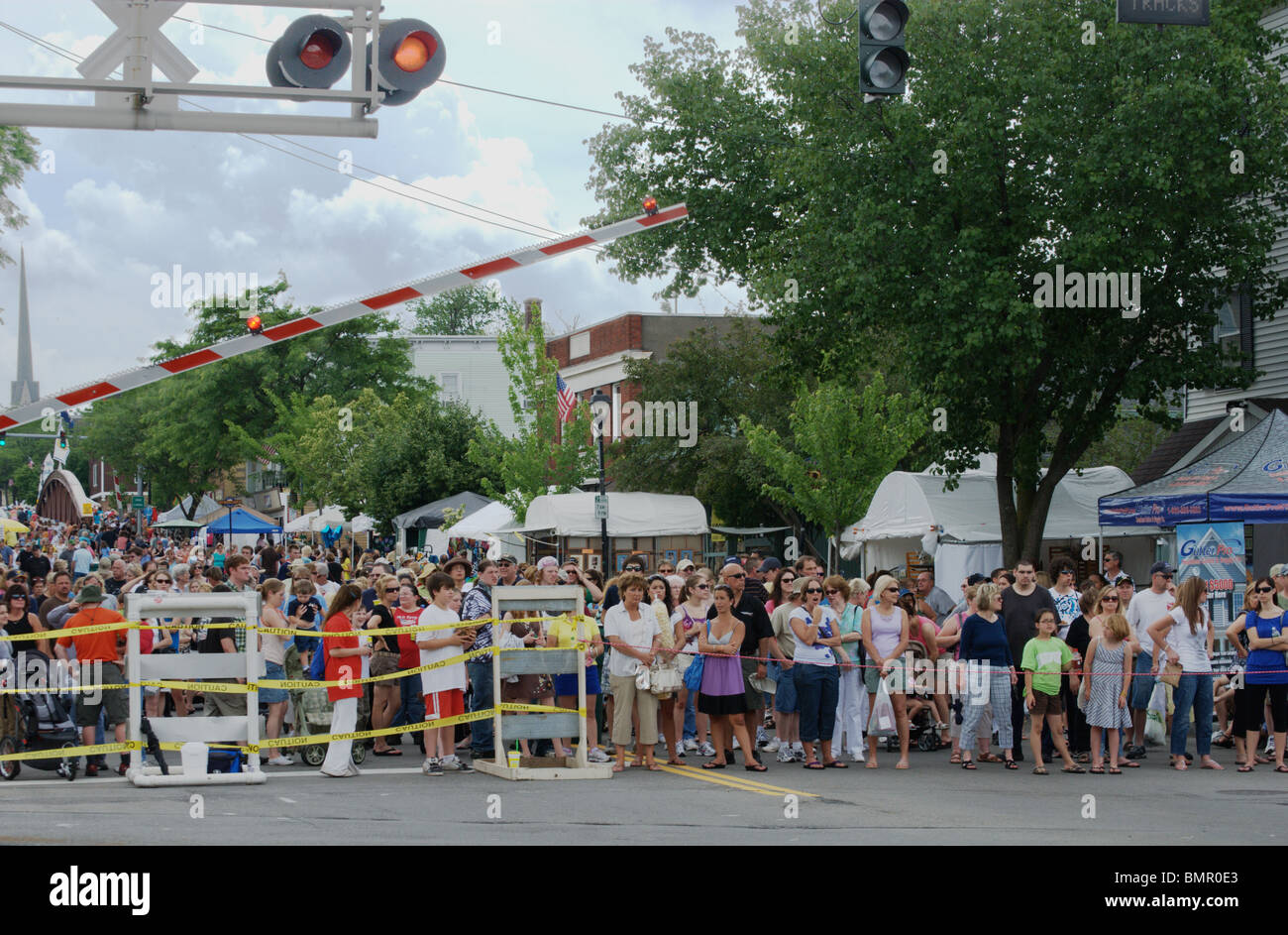 Fair going crowd wait for railroad crossing barrier to be lifted before ...