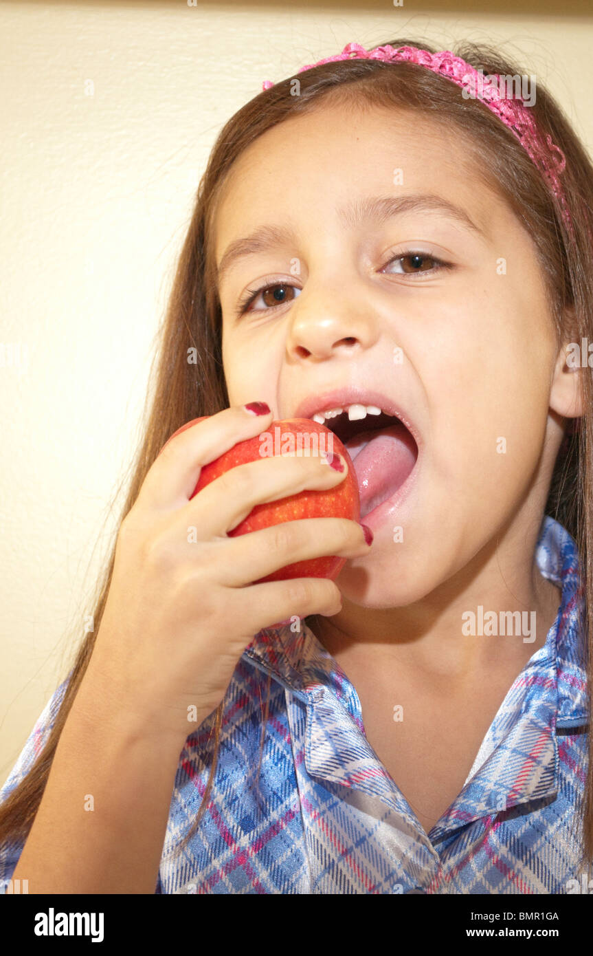 young girl with missing teeth taking a big bite of apple Stock Photo ...