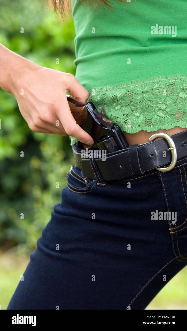 Torso of young Female Woman holding gun in belt Stock Photo - Alamy