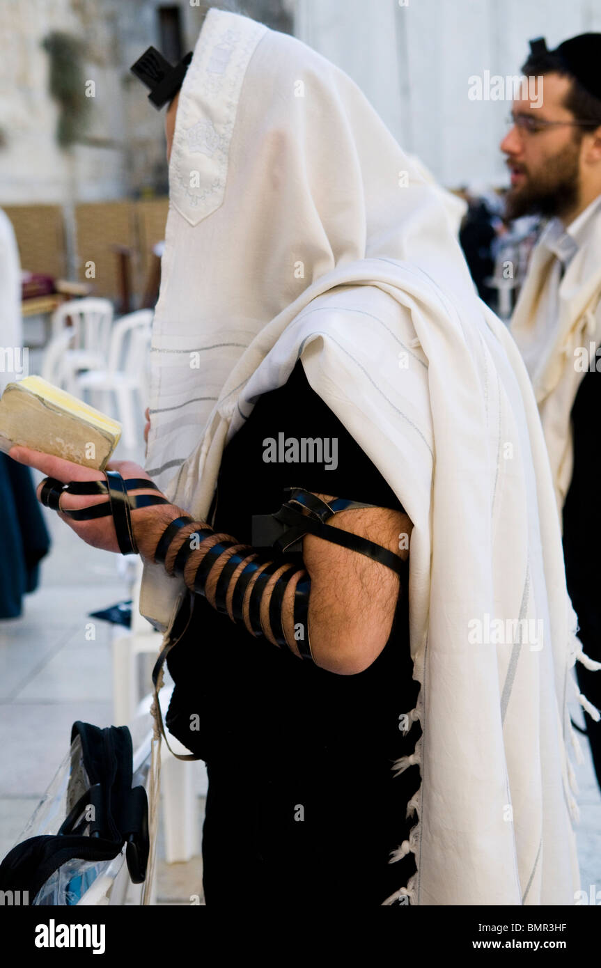 A orthodox Jewish man praying by the wailing wall in the old city of ...