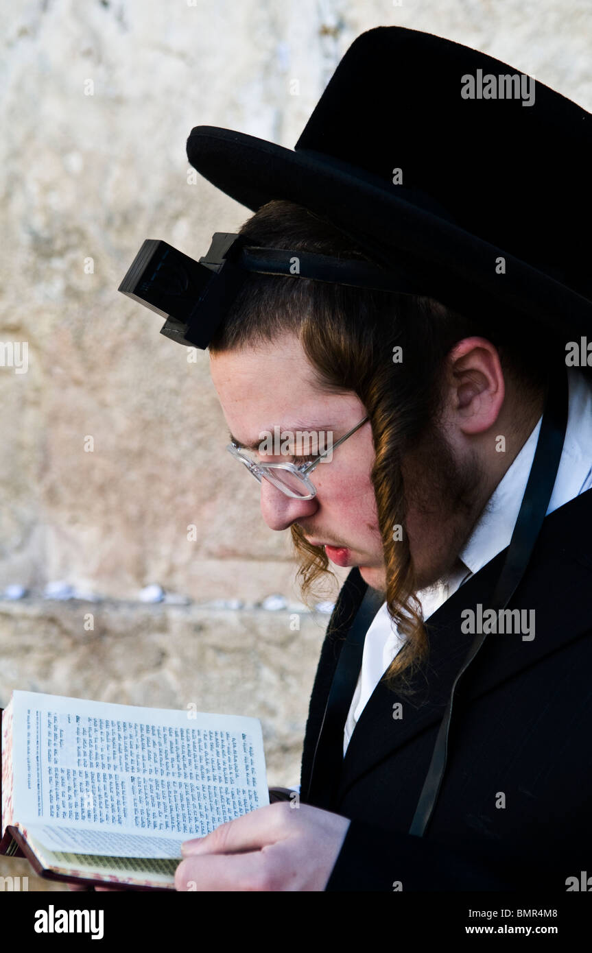 A orthodox Jewish man praying by the wailing wall in the old city of ...