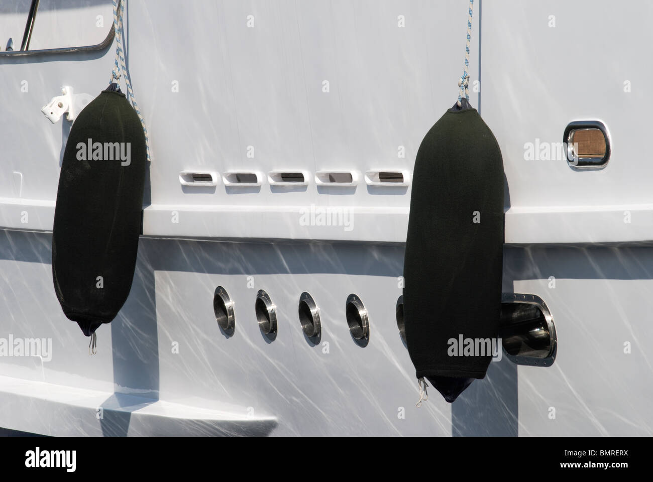 Side of superyacht with vents and hanging fenders in harbour at Cannes ...
