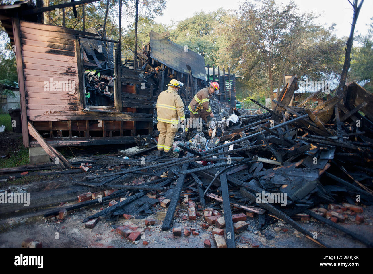 Firemen inspect rubble after house fire Stock Photo - Alamy