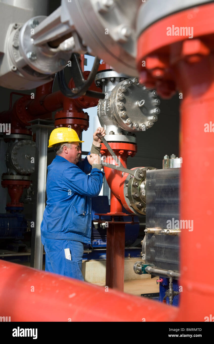 An engineer working on the piping of geothermal generating station ...