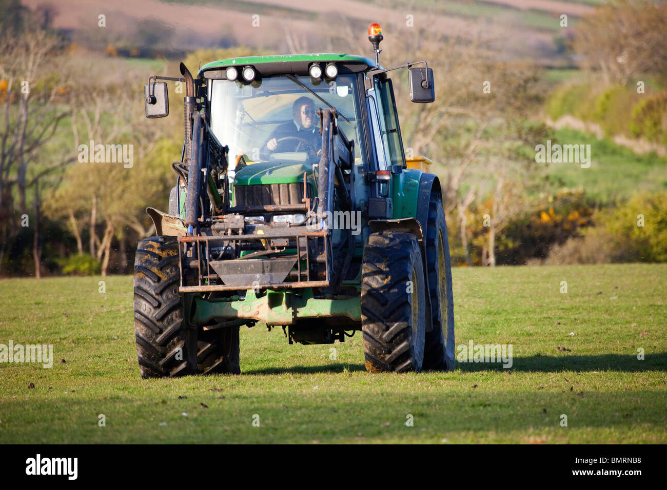 Green Farm tractor spreading fertilizer on field, Farming in ...