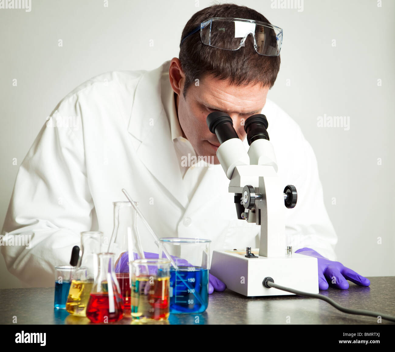 Scientist working with chemicals and a microscope in his laboratory ...