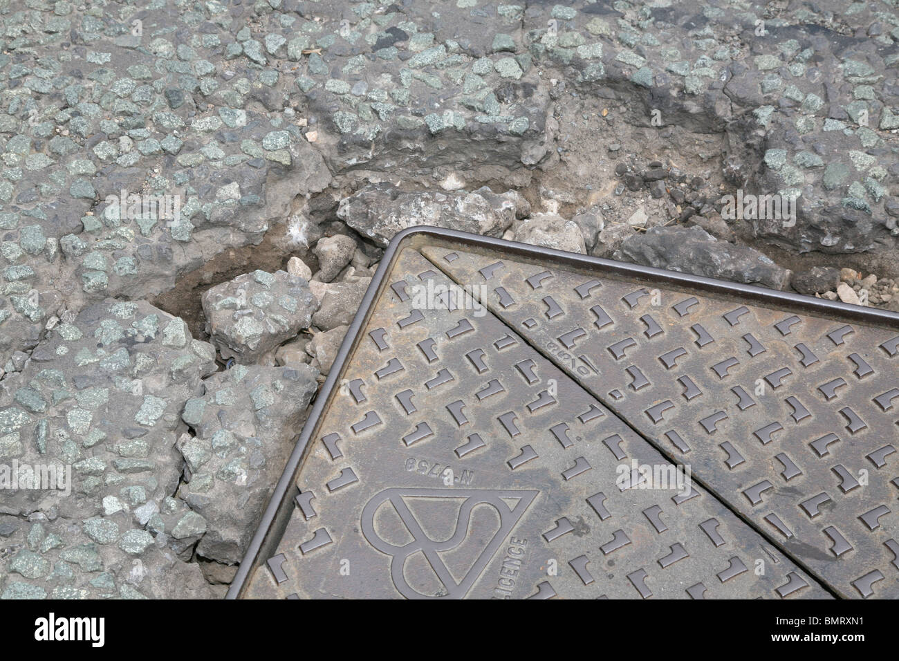 pothole damage around a manhole cover Stock Photo - Alamy