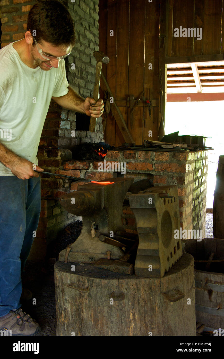 Blacksmith hammering red hot iron Vermilionville Cajun Creole heritage ...