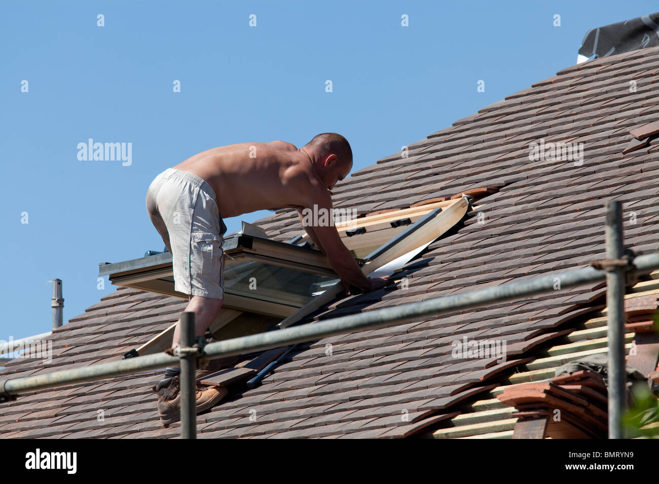 tiling a new roof around roof windows Stock Photo - Alamy