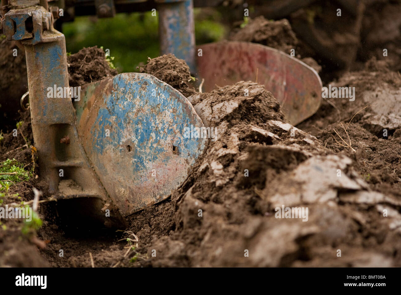 Close up of the rear end of a tractor while plowing, some motion blur ...
