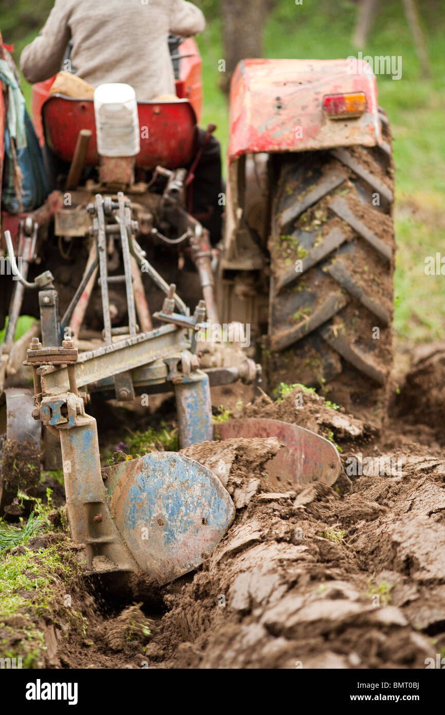 Close up of the rear end of a tractor while plowing, some motion blur ...