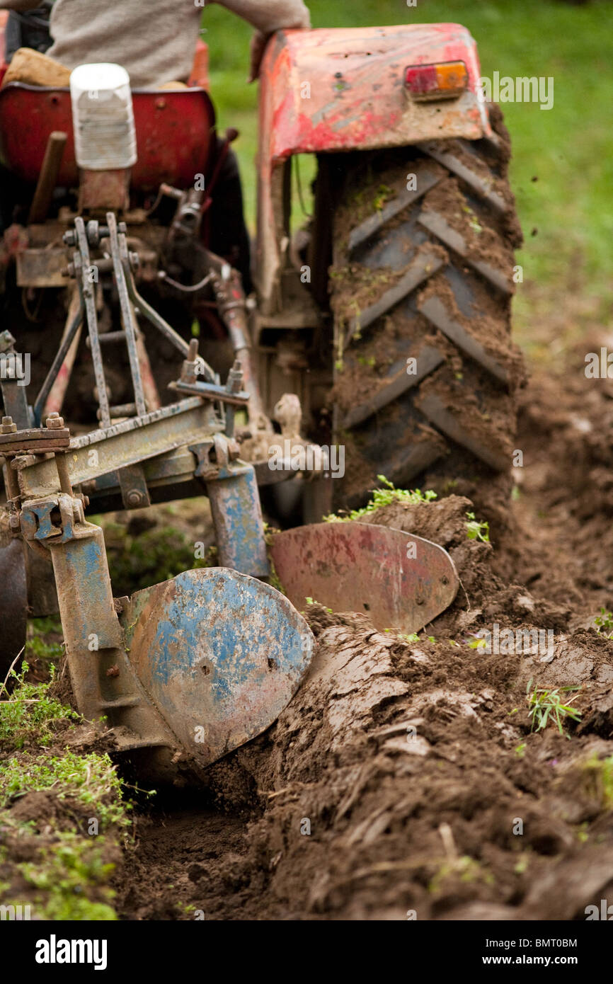 Close up of the rear end of a tractor while plowing, some motion blur ...