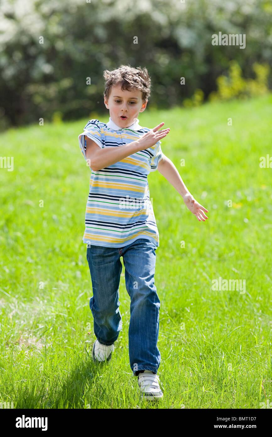 Portrait of a little boy running on a meadow Stock Photo - Alamy