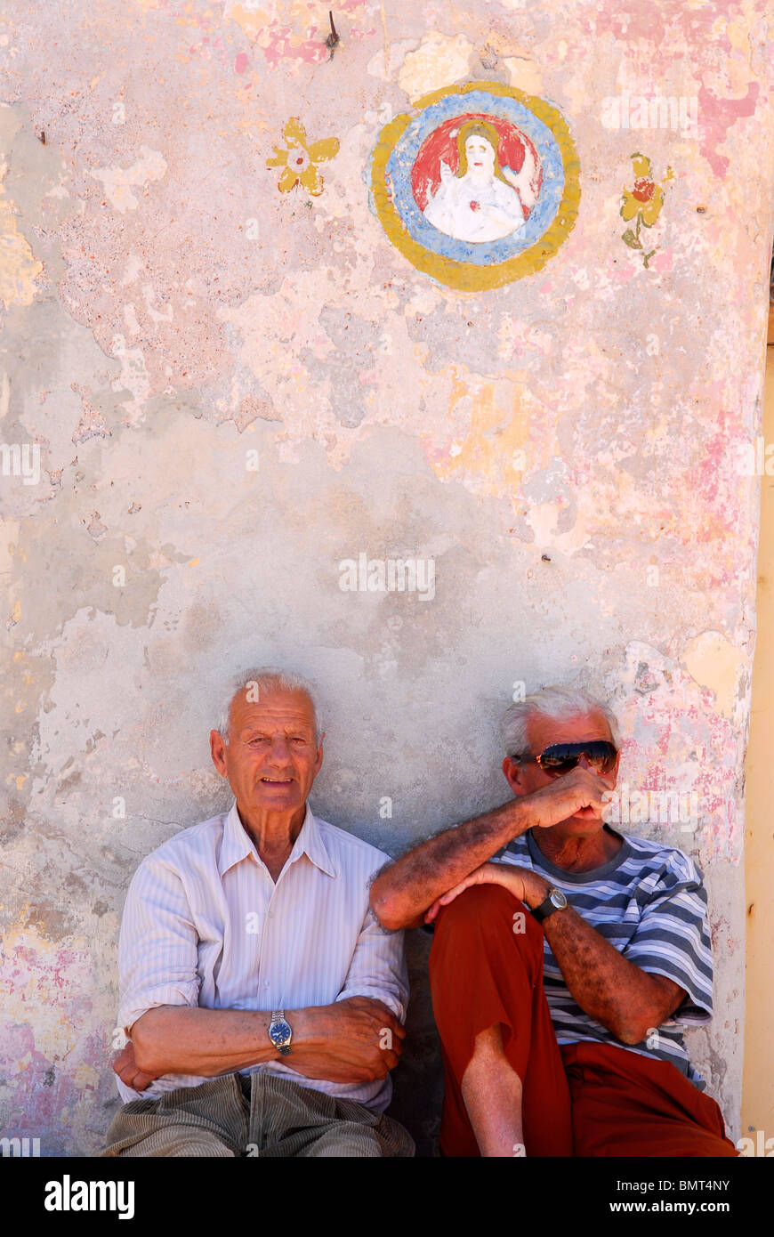 Two elderly Maltese men sitting down at the harbour in Marsaxlokk ...
