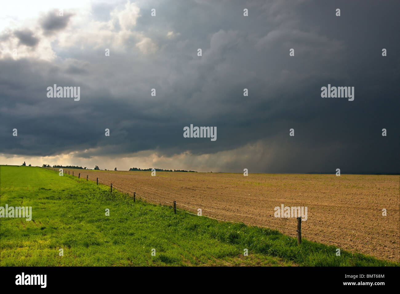 Raining from thunder clouds on field Stock Photo - Alamy