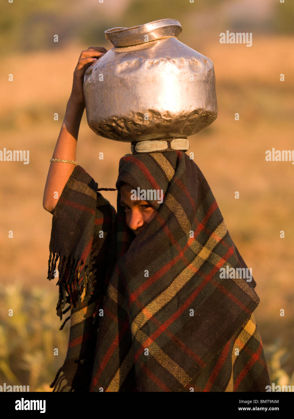 Rajasthan,India;Woman Carrying A Metal Pot On Her Head Stock Photo - Alamy