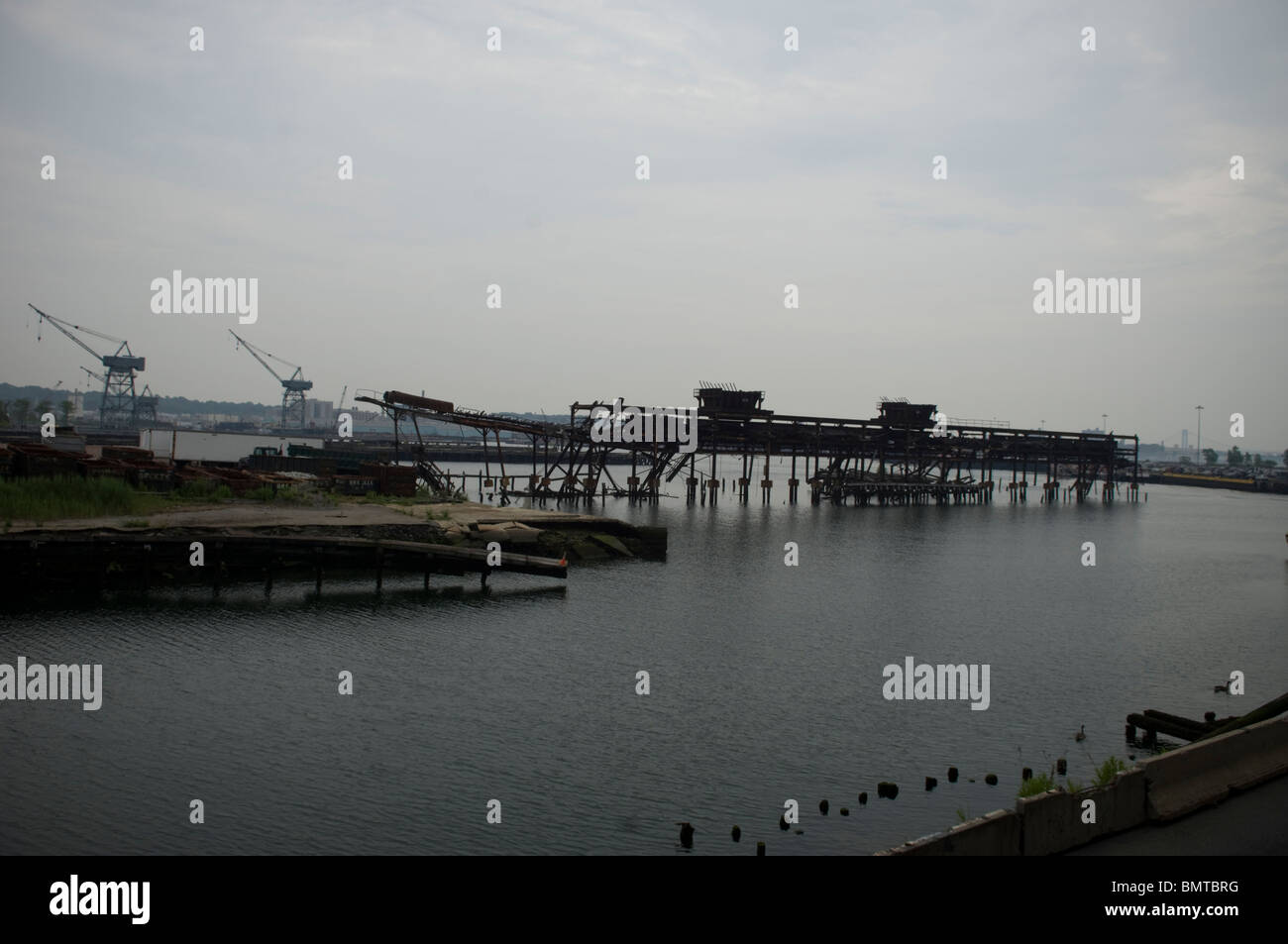 An abandoned pier and cranes on the waterfront in the Red Hook ...