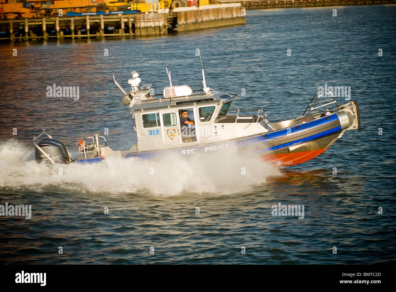 An NYPD police boat number 312 from the Harbor Unit speeds through the ...
