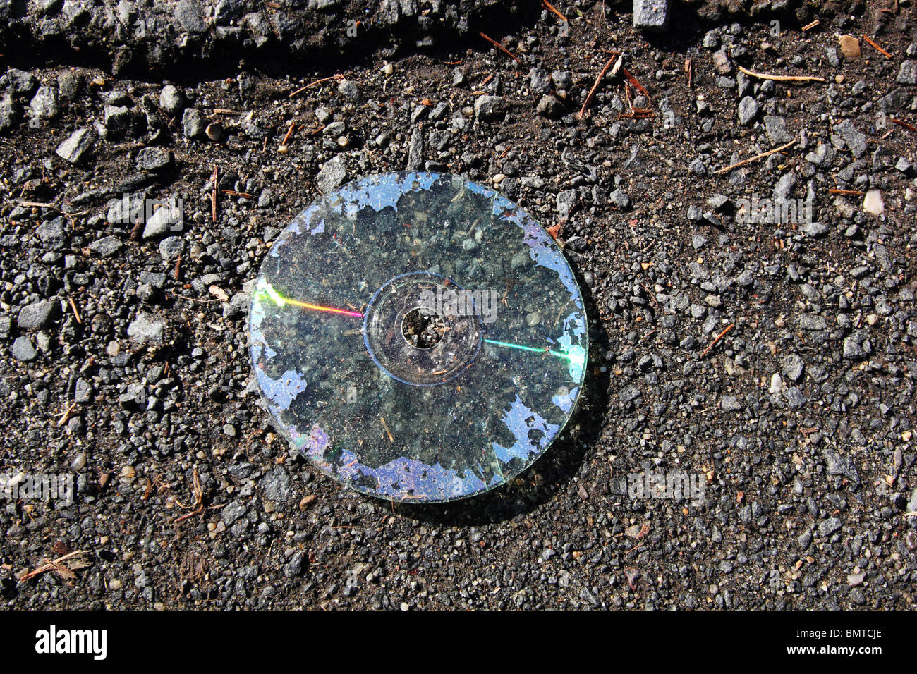 WEATHERED COMPACT DISK ON ROADSIDE SHOWING RAINBOW PATTERN HORIZONTAL ...