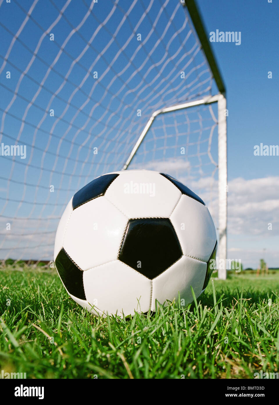 Football in the goal net against blue sky Stock Photo - Alamy