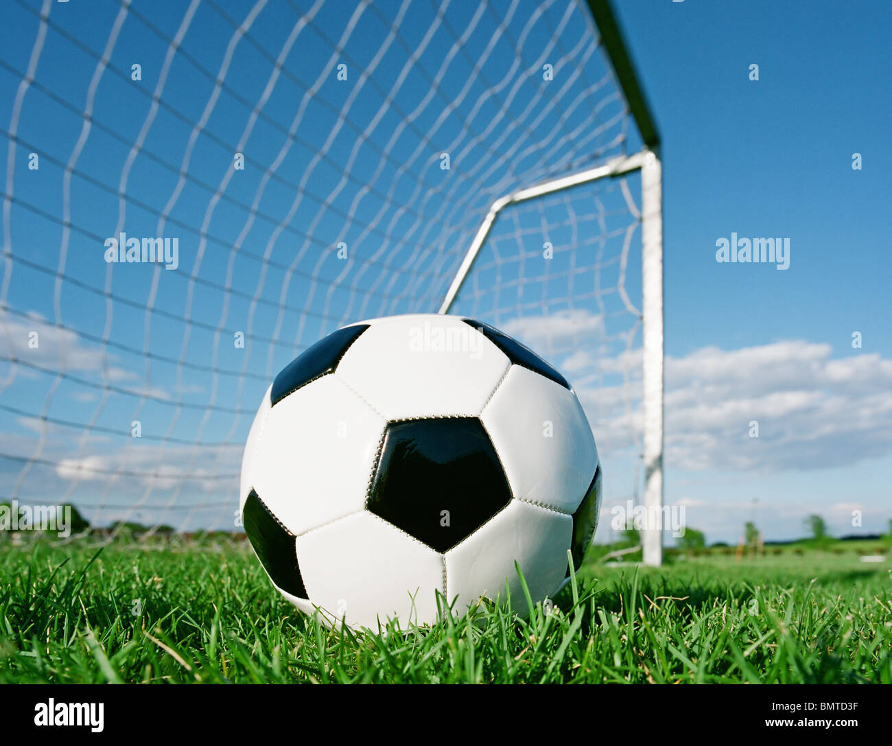 Football in the goal net against blue sky Stock Photo - Alamy