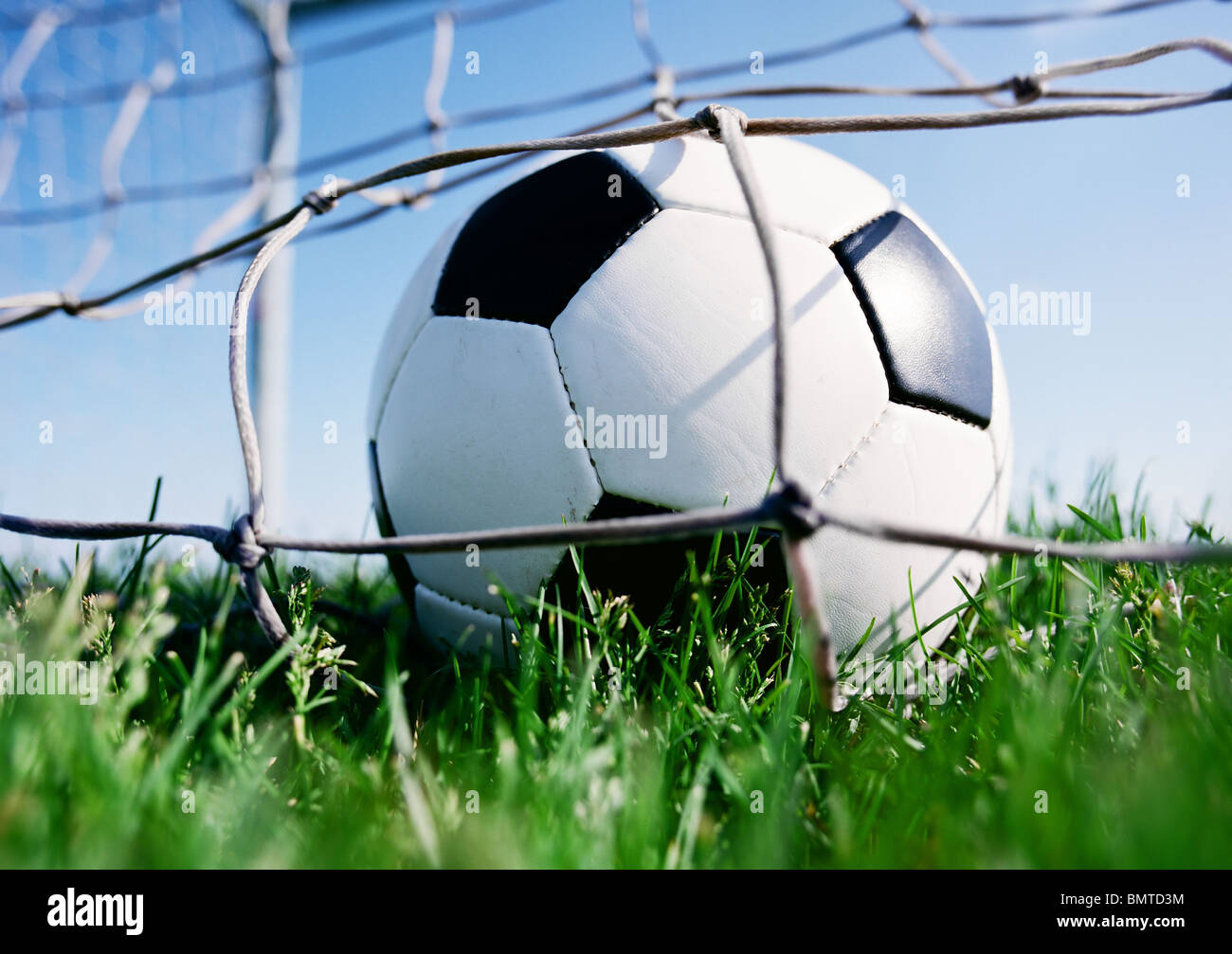 Football in the goal net against blue sky Stock Photo - Alamy