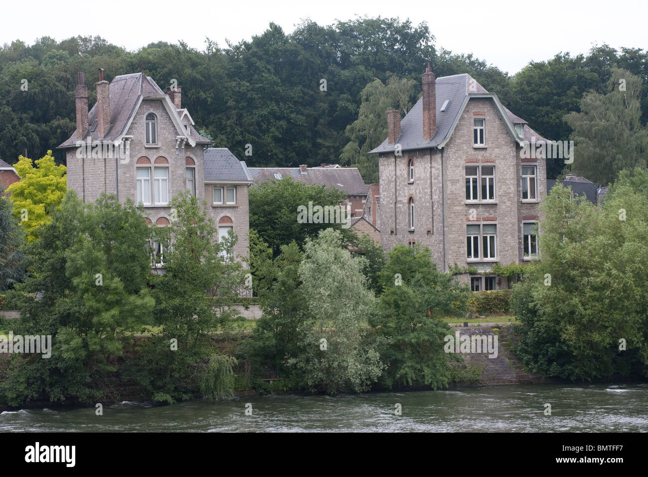 riverside village homes forest river trees chimney Stock Photo - Alamy