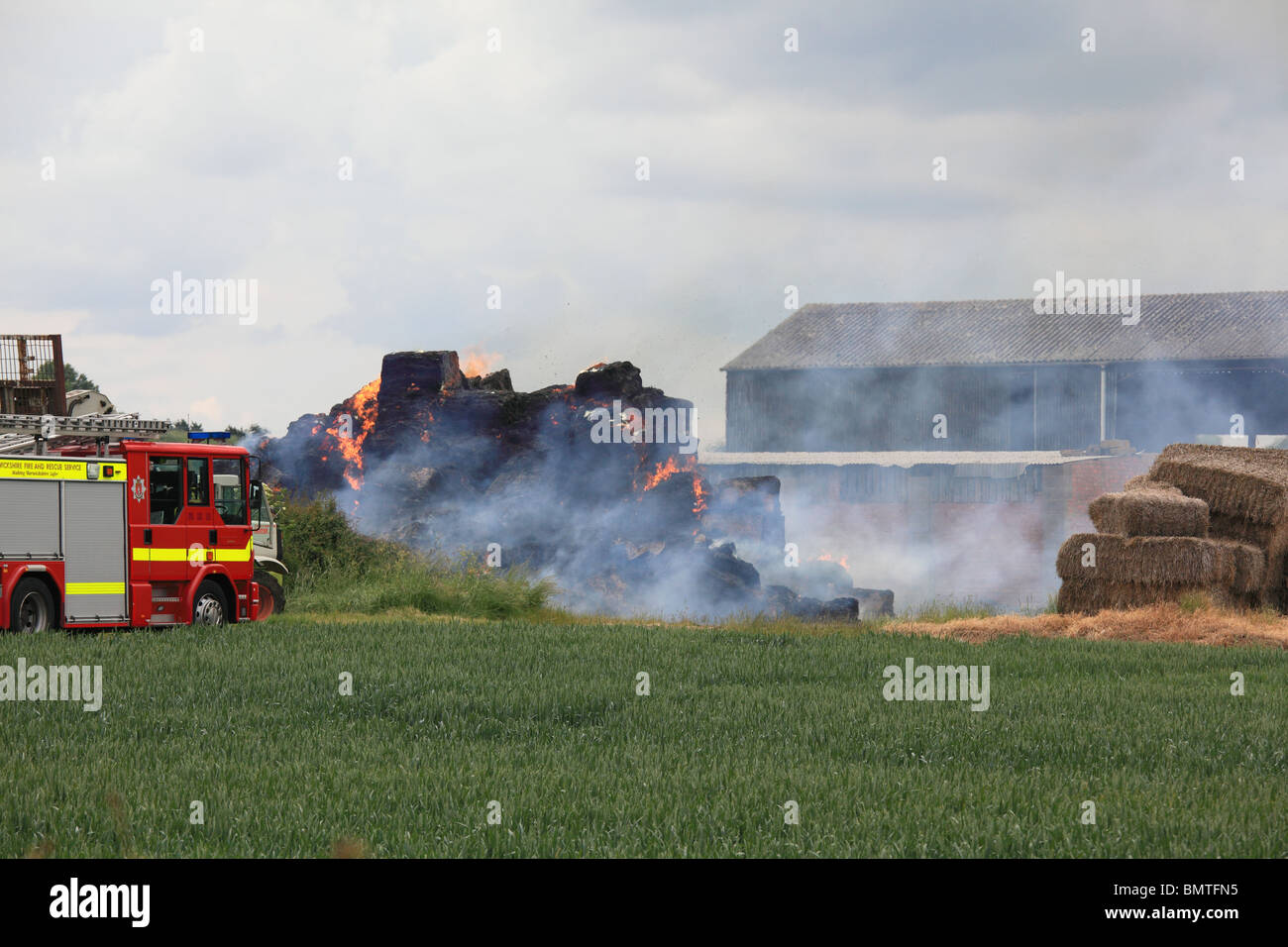 Fire engine at a fire of bales of hay at a farm in rural Warwickshire ...