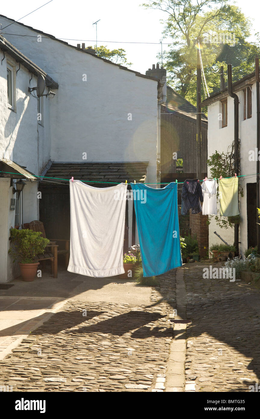 Washing drying in cobbled courtyard outside cottages Stock Photo - Alamy