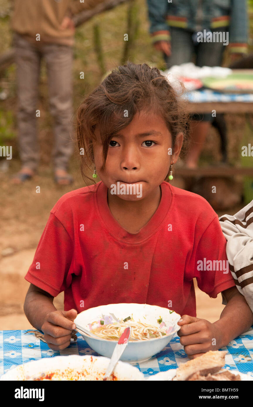 A young girl eating a bowl of noodles in Muang Ngoi Northern Laos Stock ...