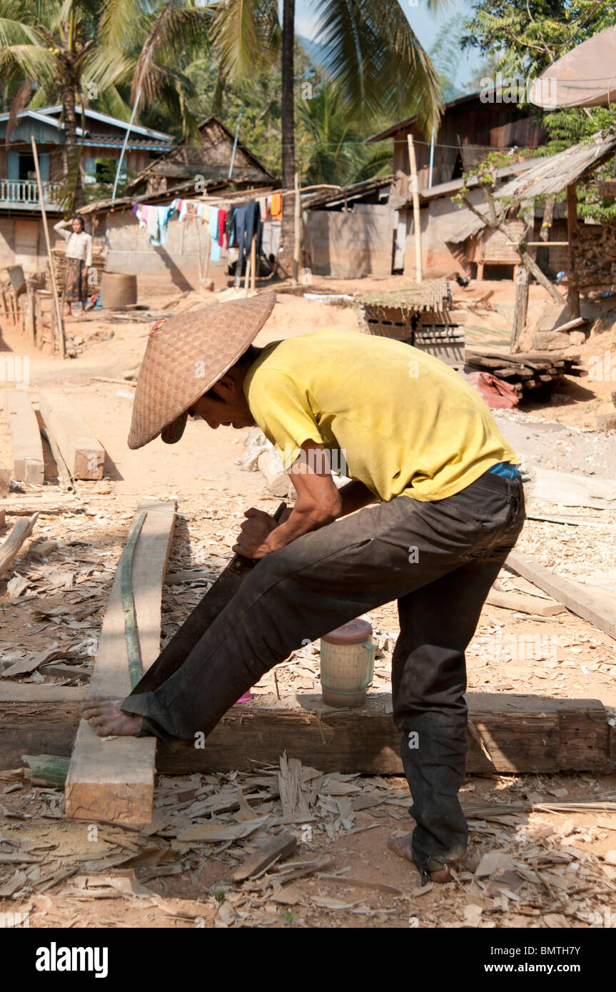 A Lao man sawing wood in a tribal village in Vong Xai province Northern ...