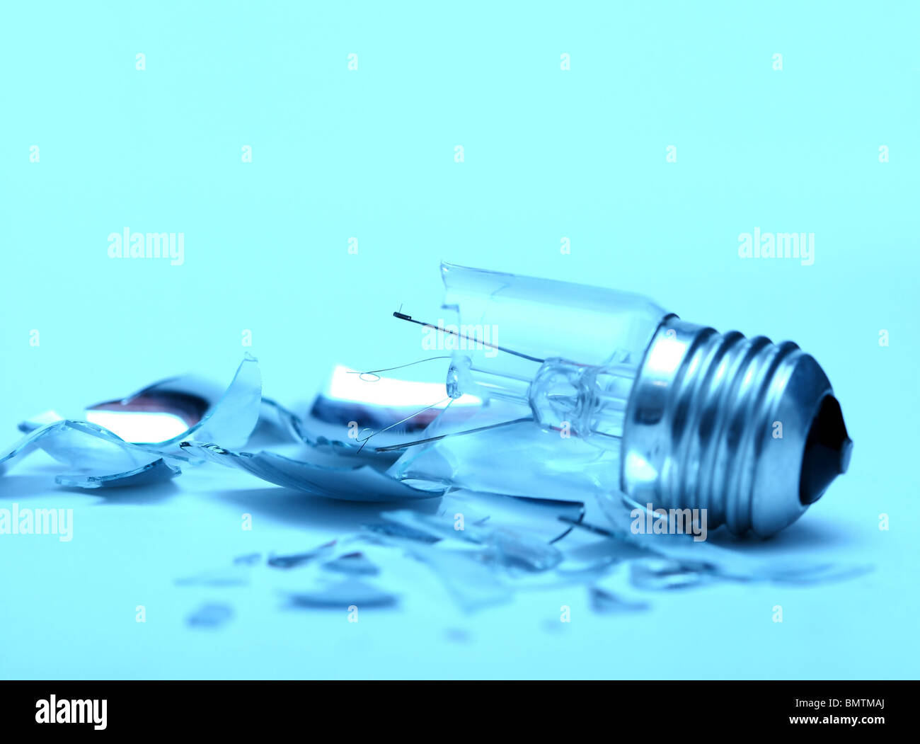 Broken lightbulb and it's fragments around on blue background Stock ...